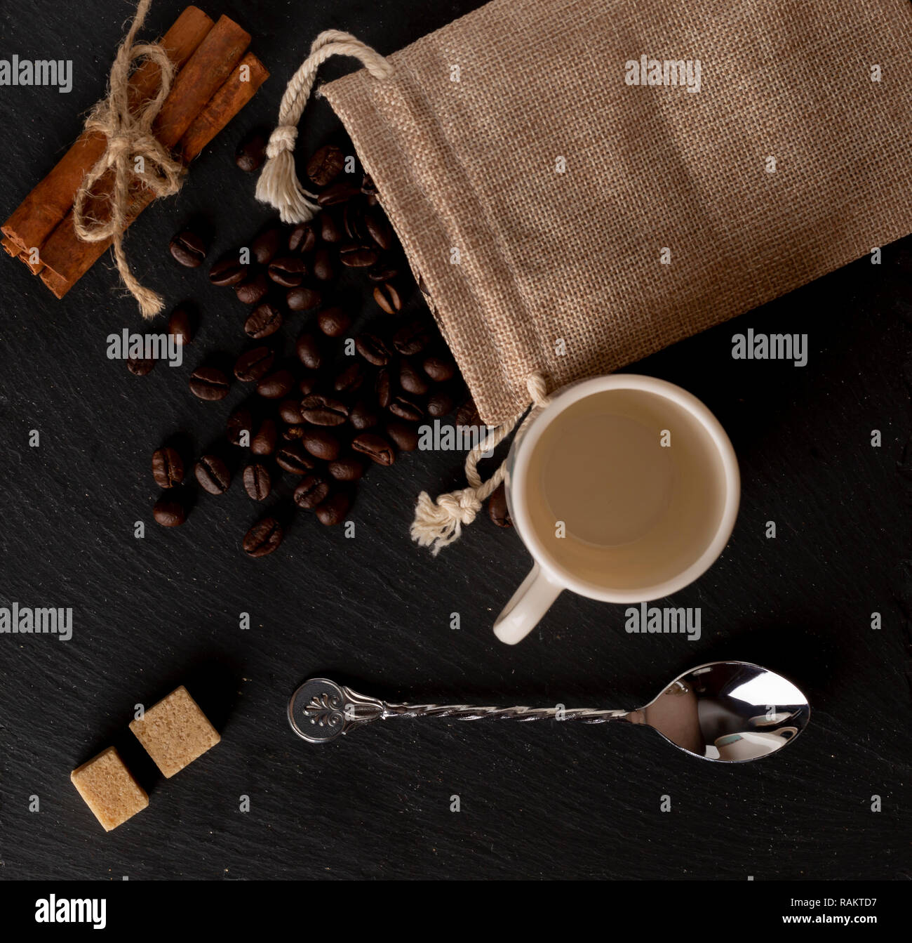 burlap with roasted coffee beans, cane sugar, coffee cup on stone ...