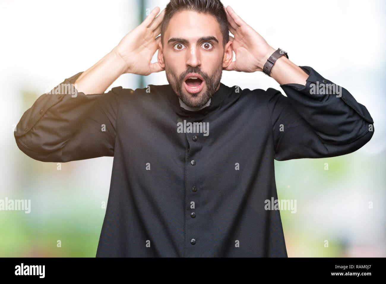 Young Christian priest over isolated background Crazy and scared with ...