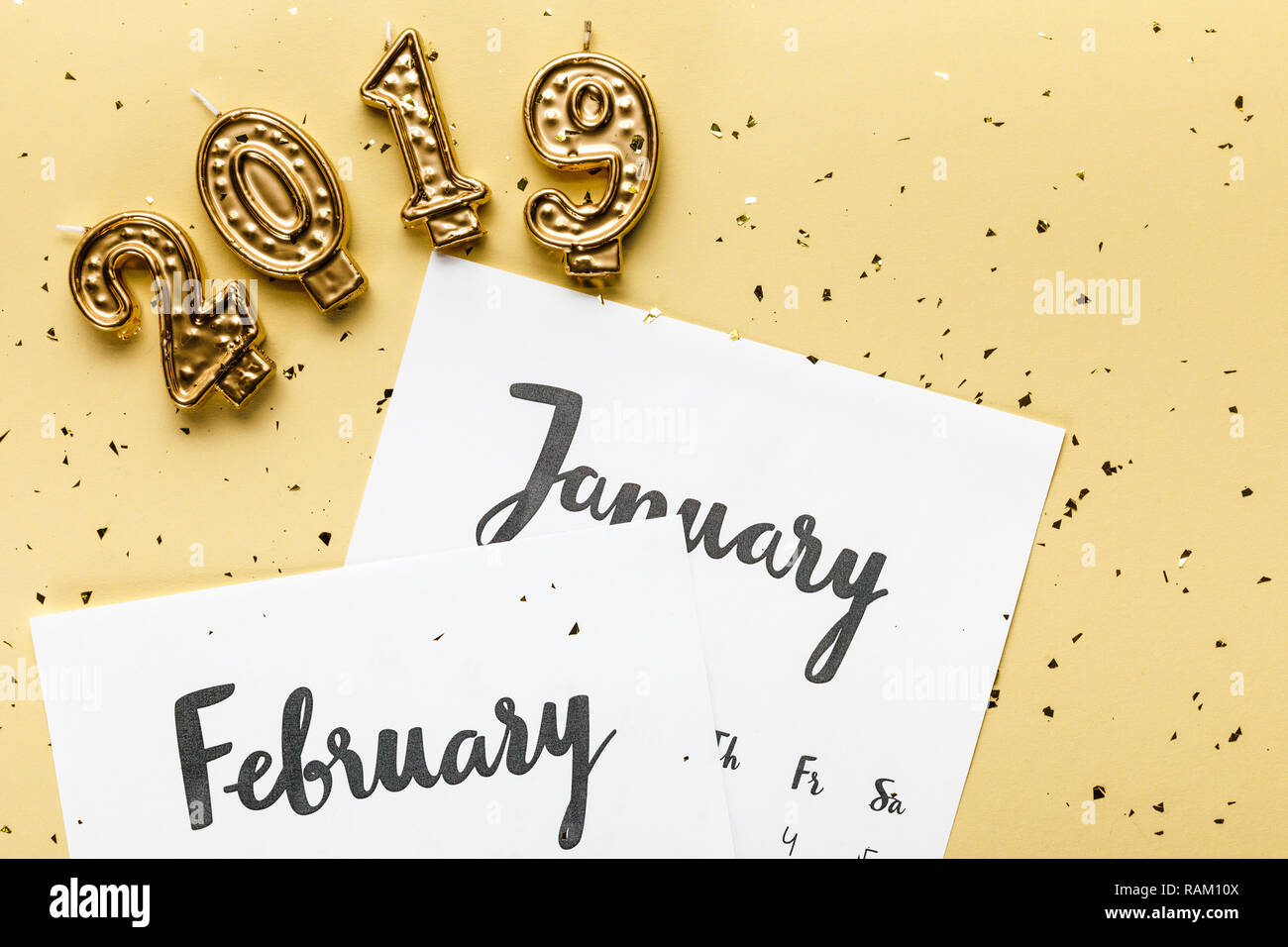 top view of winter calendar, 2019 candles and golden confetti on beige ...