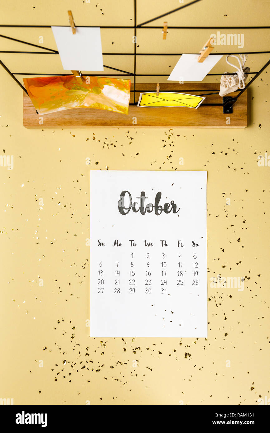 top view of october calendar with golden confetti and cards with ...
