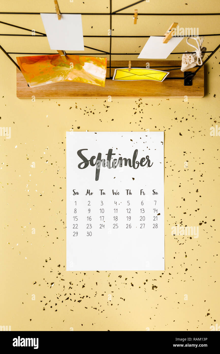 top view of september calendar with golden confetti and cards with ...