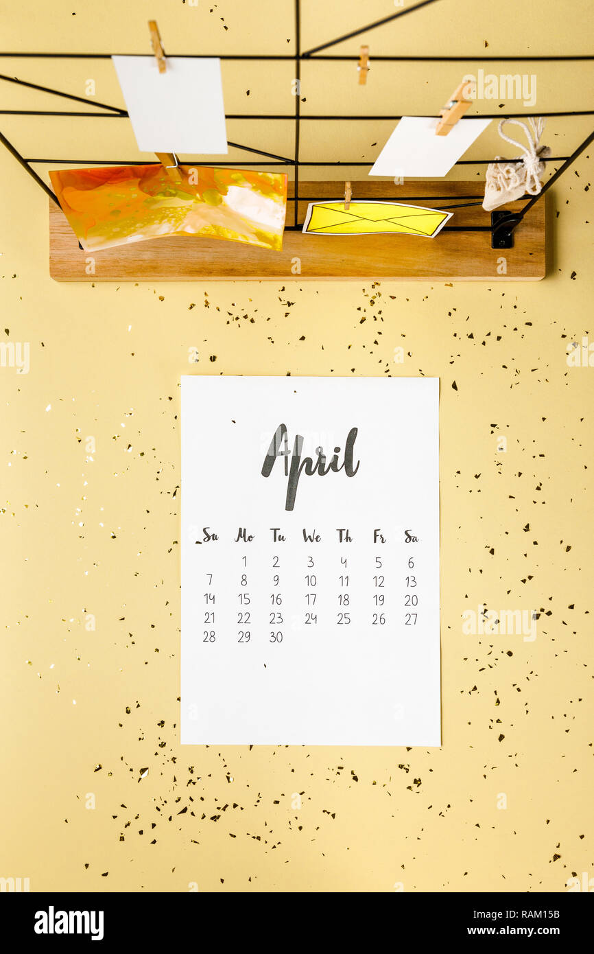 top view of april calendar with golden confetti and cards with ...