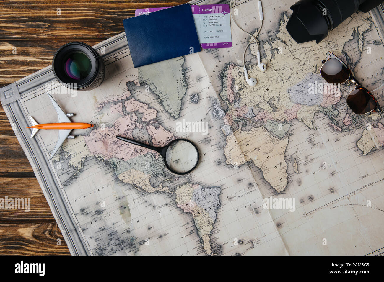 top view of magnifying glass, small model plane, sunglasses, photo ...