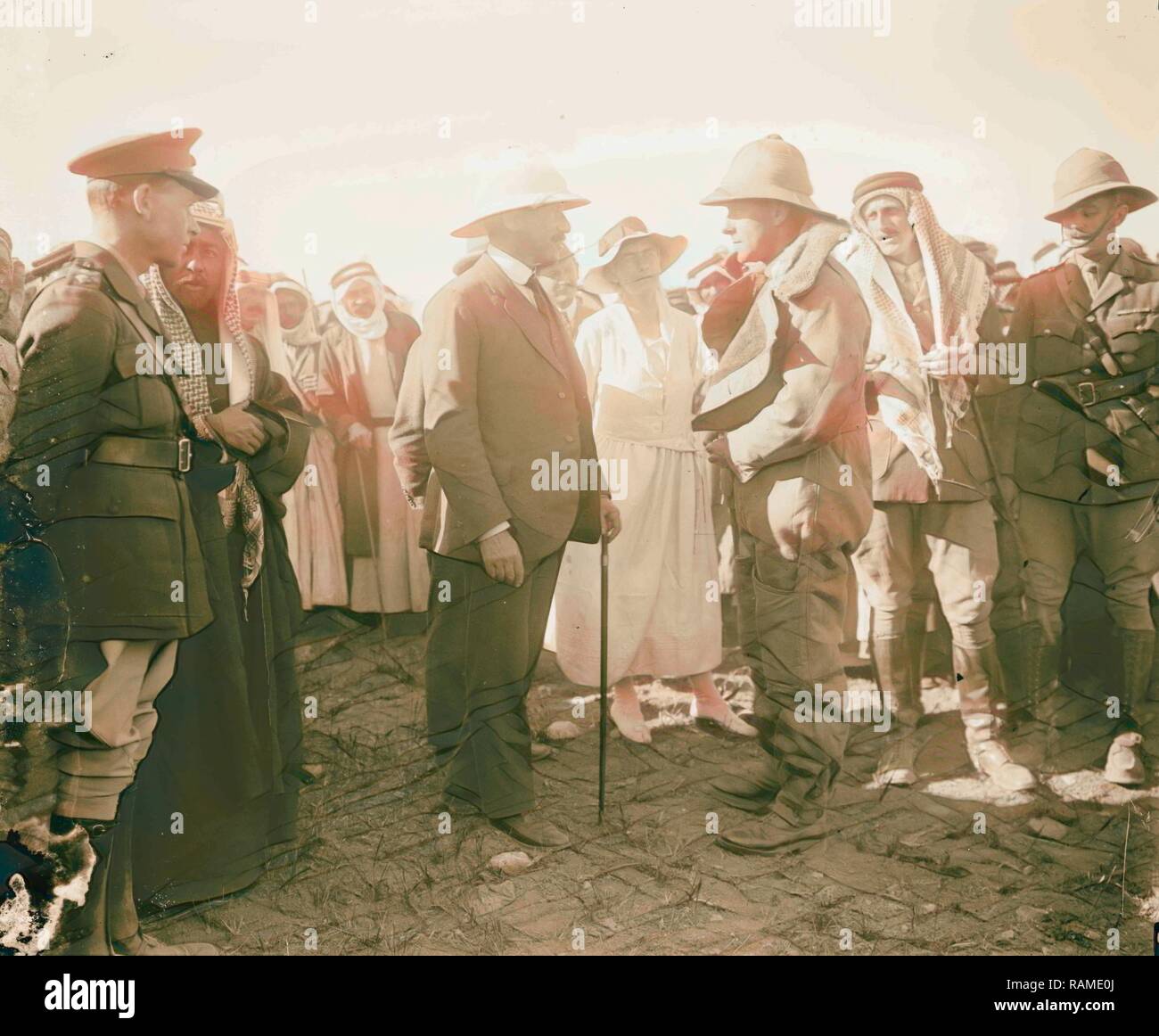 Pilot in flight suit greets Sir Herbert Samuel. Gertrude Bell(?) stands ...