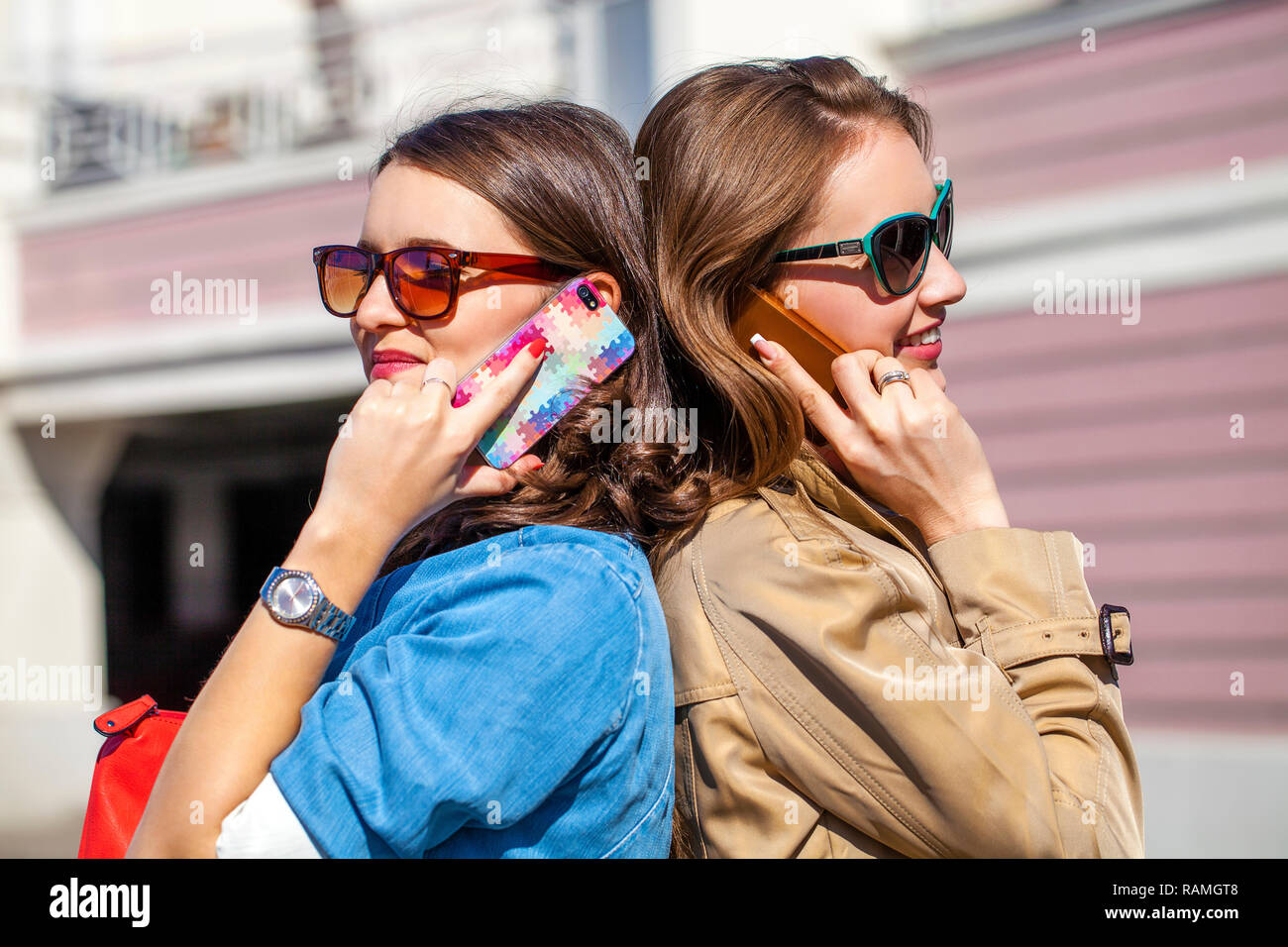Two Young Women with Mobile Phone on spring street background Stock ...