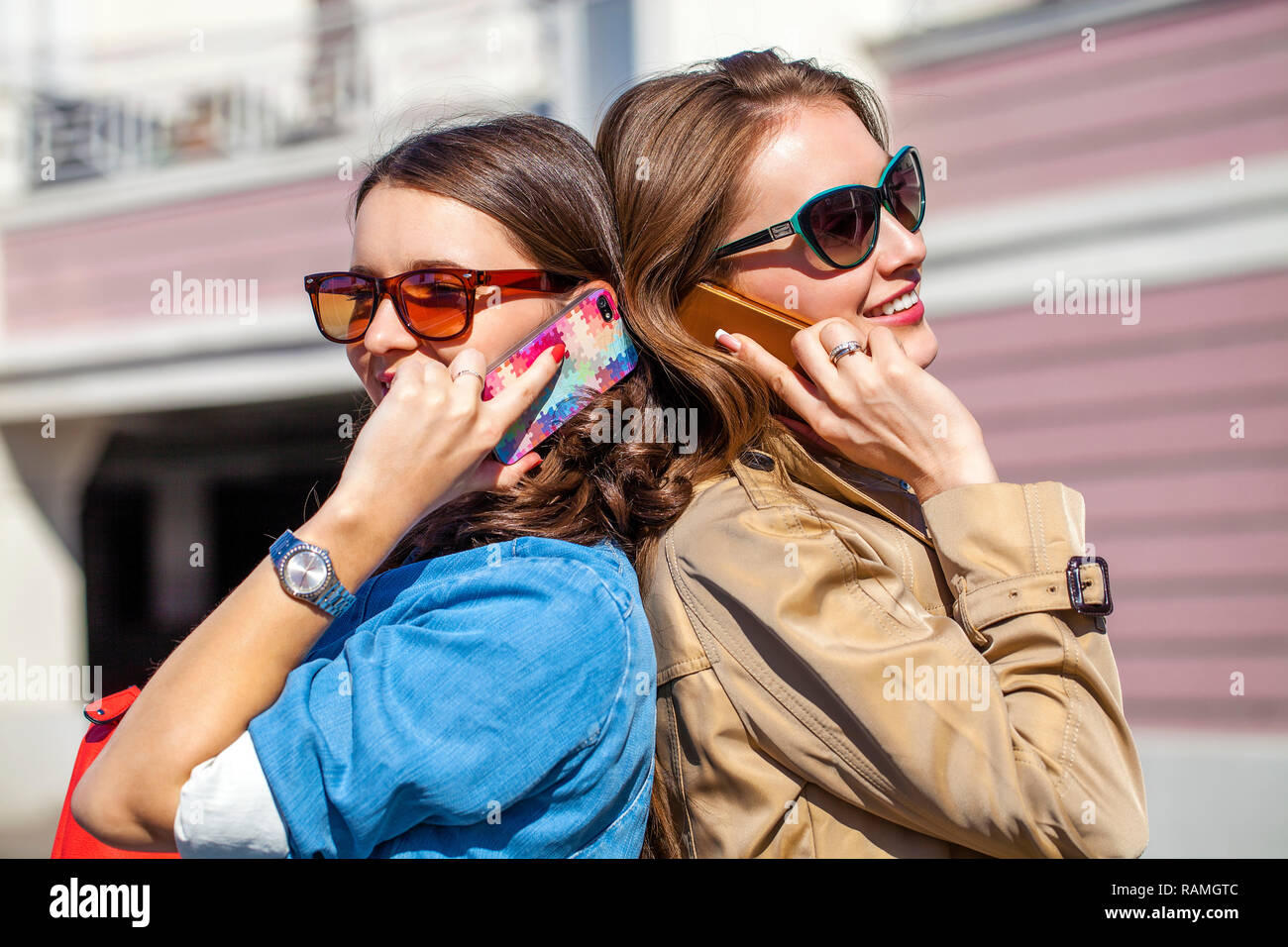 Two Young Women with Mobile Phone on spring street background Stock ...