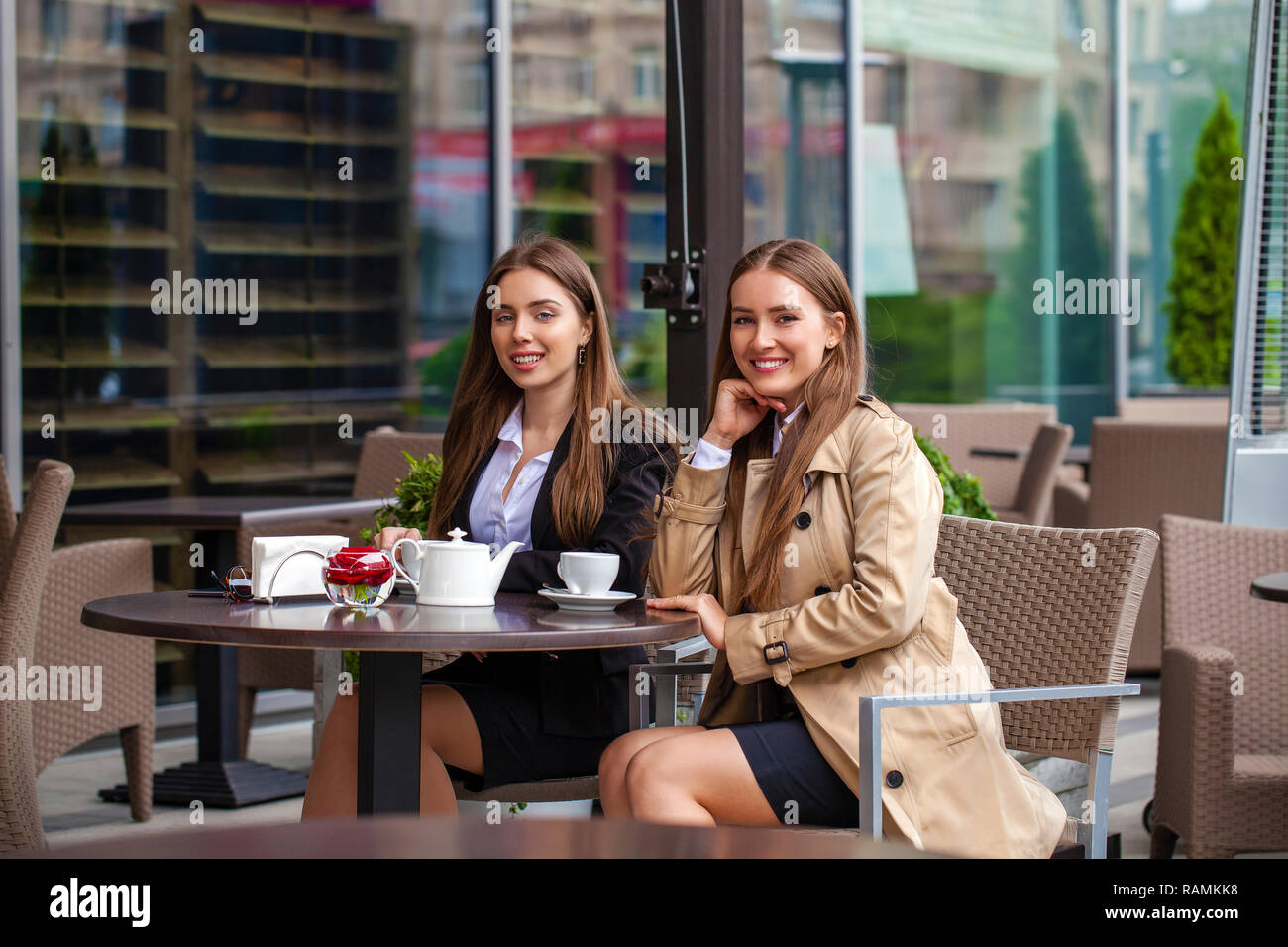 Two young business women having lunch break together in a coffee shop ...