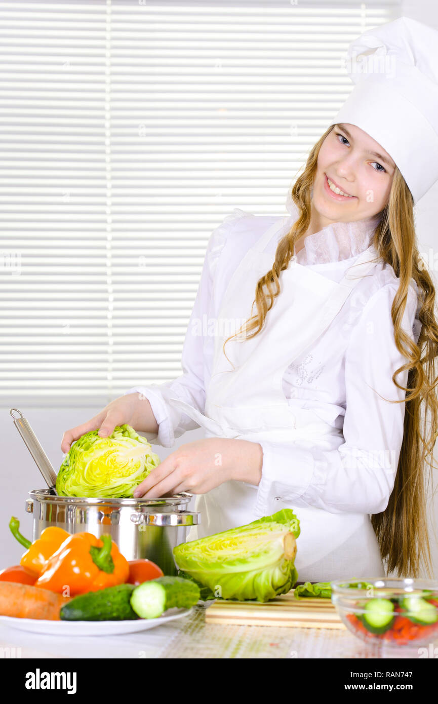 Girl wearing chef uniform cooking on kitchen Stock Photo - Alamy