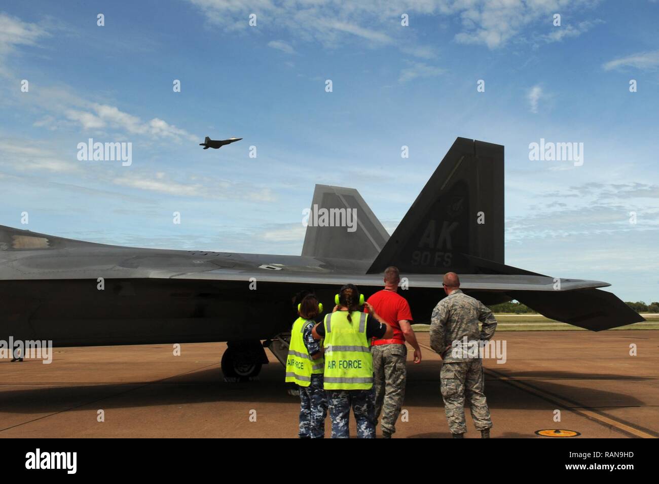 U.S. and Royal Australian Air Force maintenance airmen watch as an F-22 ...