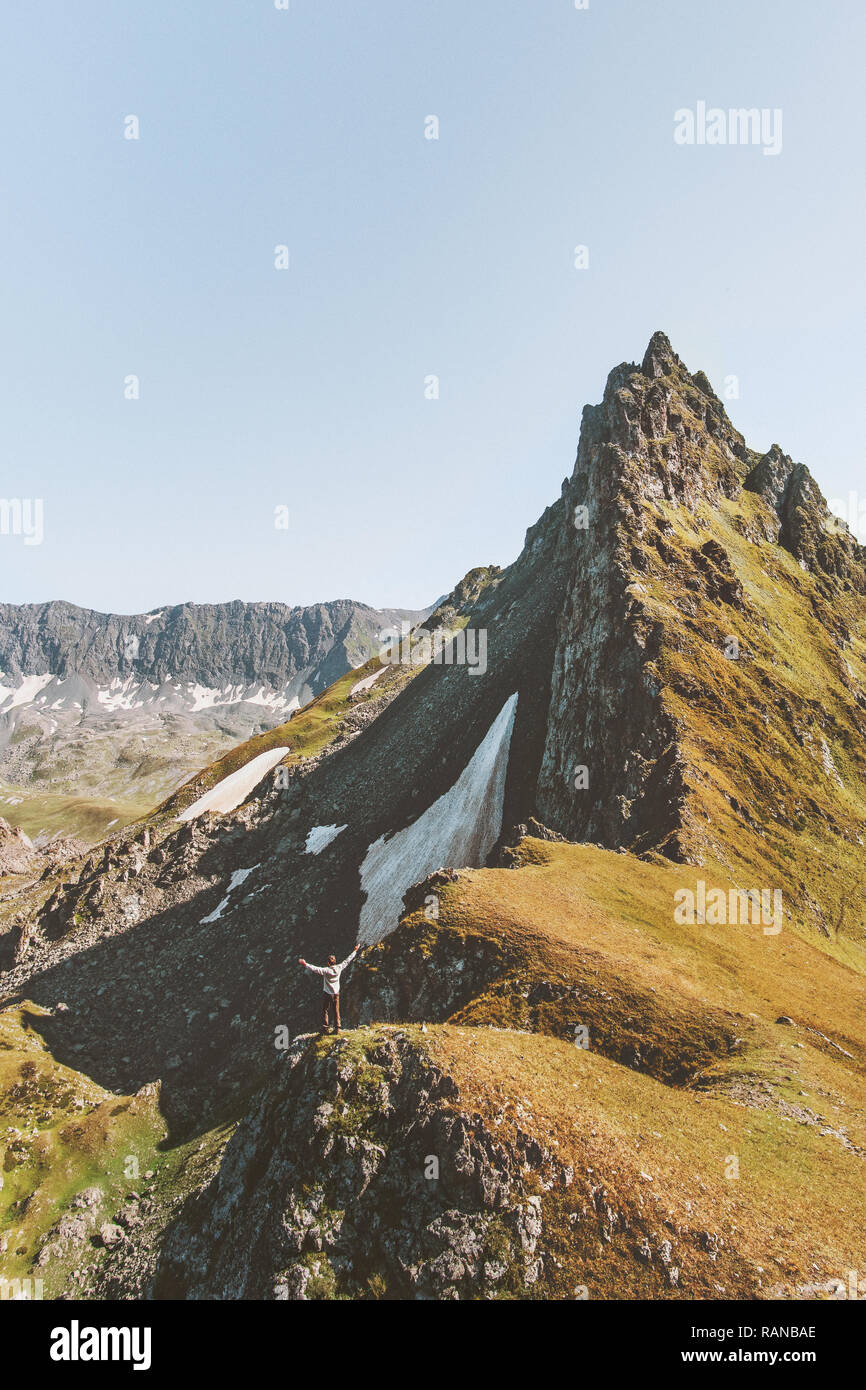 Man climbing in mountains standing on cliff edge adventure active ...