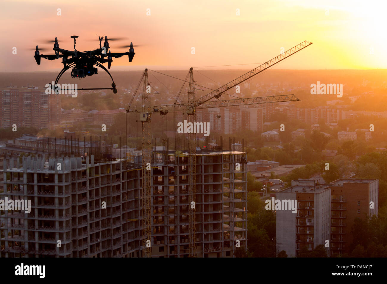 Quad copter over building under construction Stock Photo - Alamy