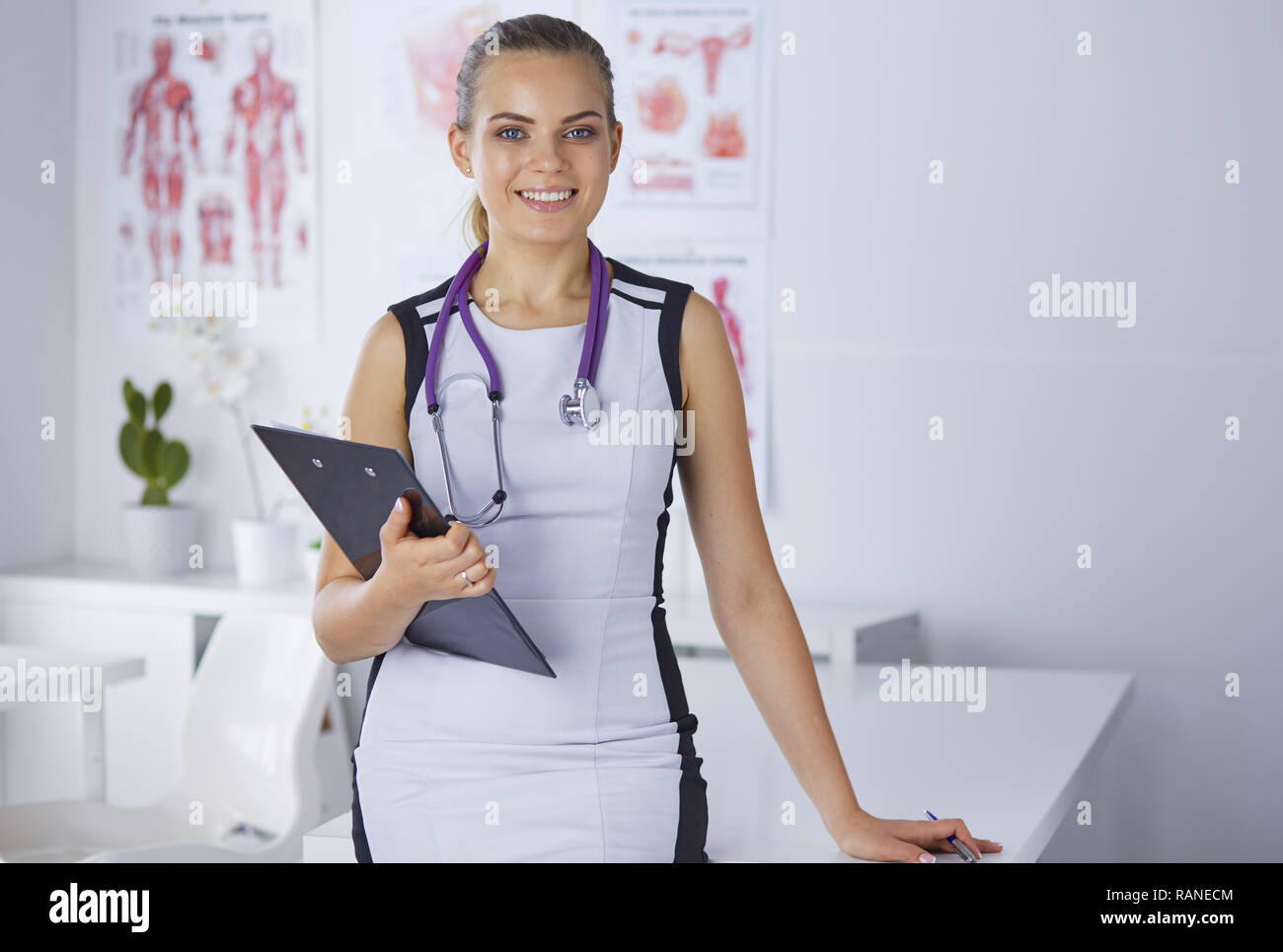 A young female doctor at a desk in the office. The concept of health ...