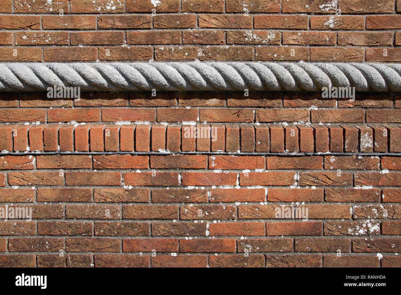 Old weathered brick wall background with stone rope pattern detail ...
