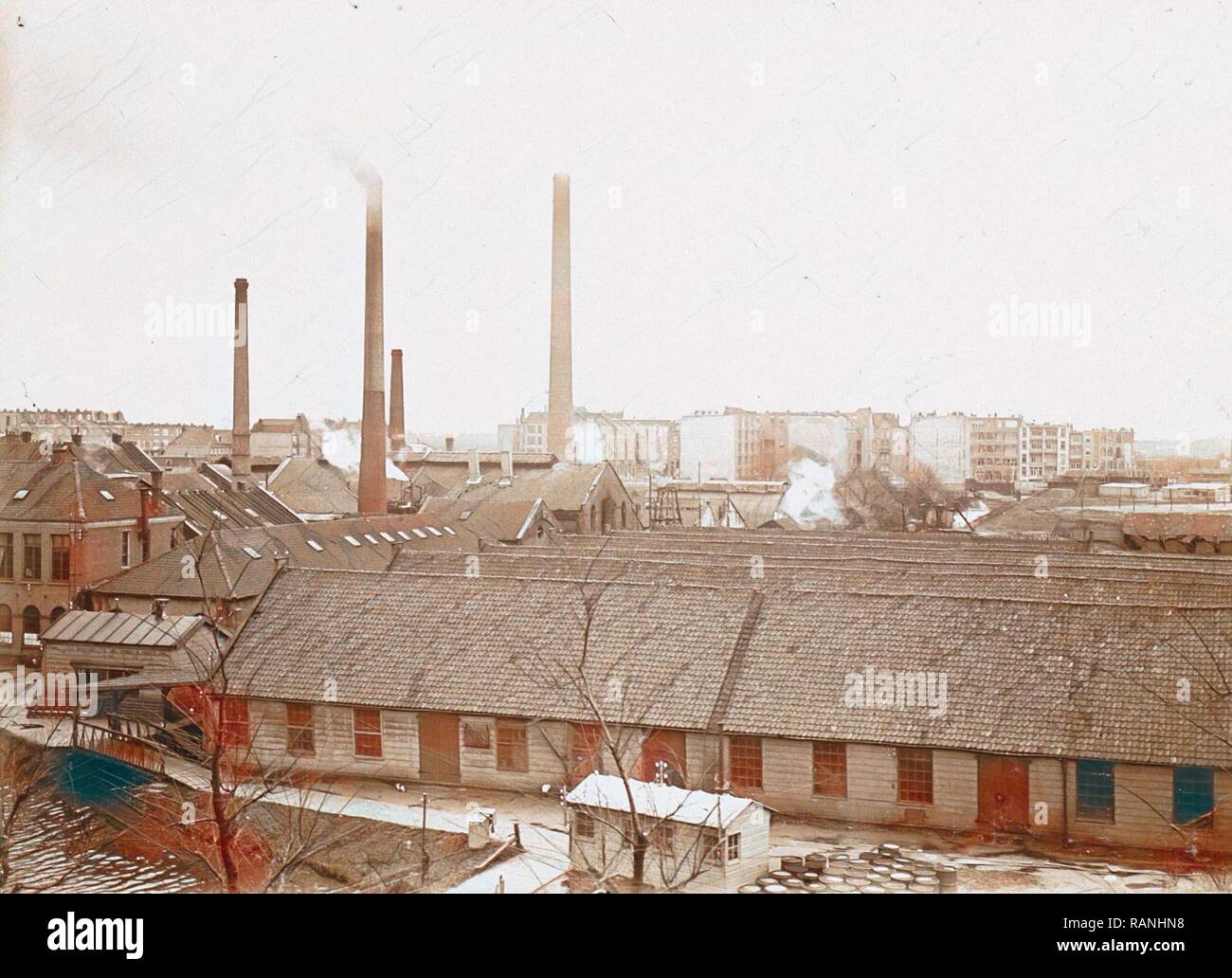 Exterior of factory buildings with chimneys, in the foreground wooden ...