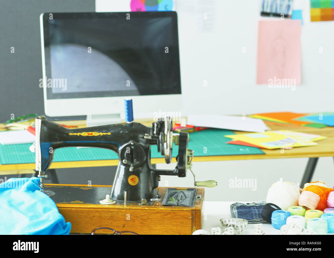 Retro sewing machine on designer clothes desktop Stock Photo - Alamy
