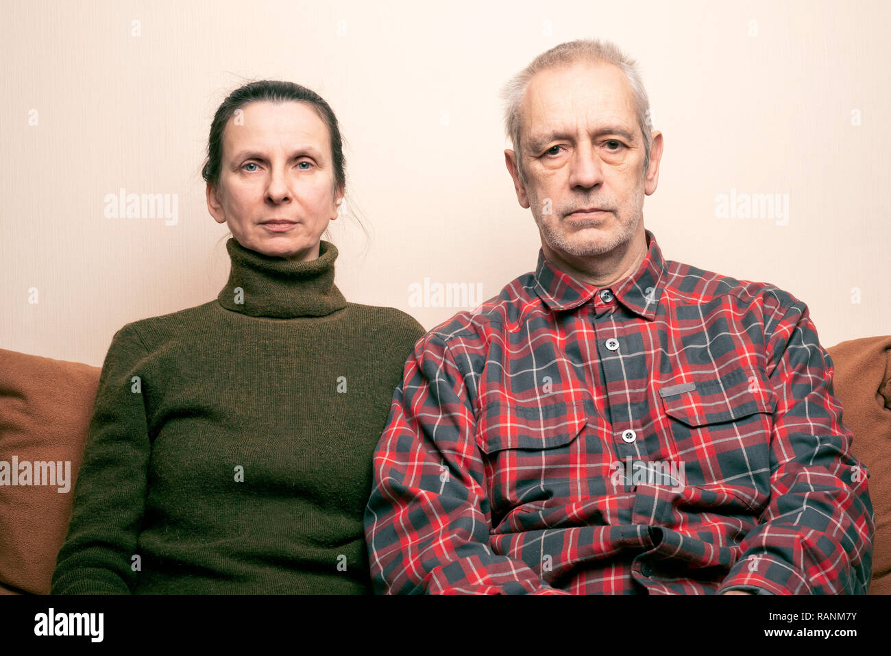 Dramatic portrait of sad and depressed adult woman and man sit on a ...