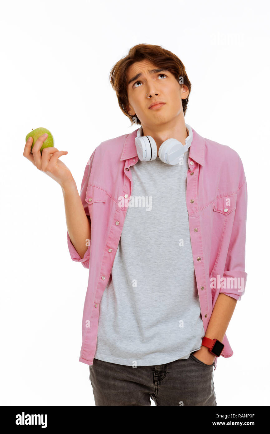 Nice thoughtful boy thinking about the apple Stock Photo - Alamy