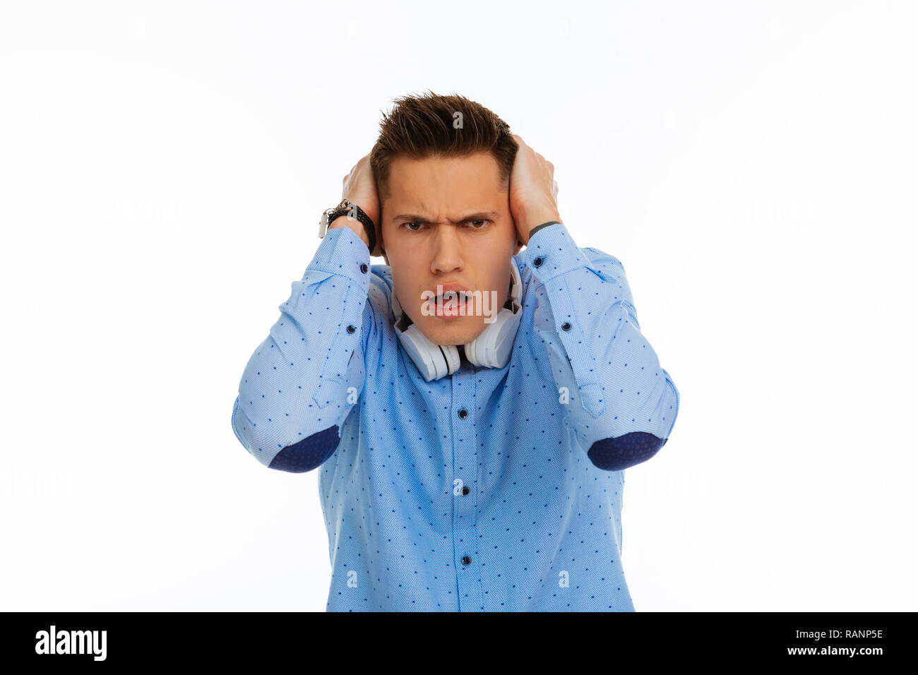 Angry emotional young man covering his ears Stock Photo - Alamy