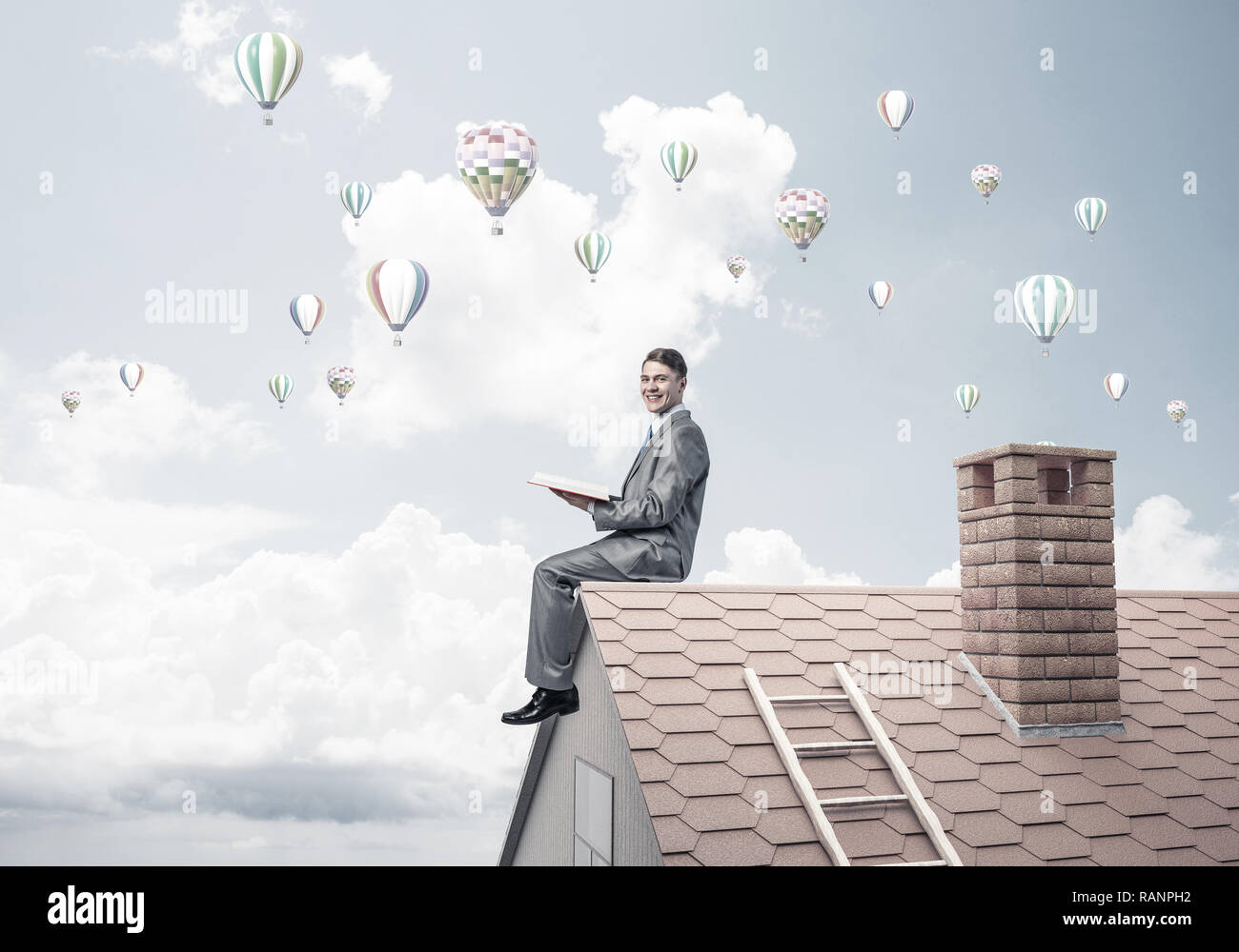 Man on brick roof reading book and aerostats flying in air Stock Photo ...