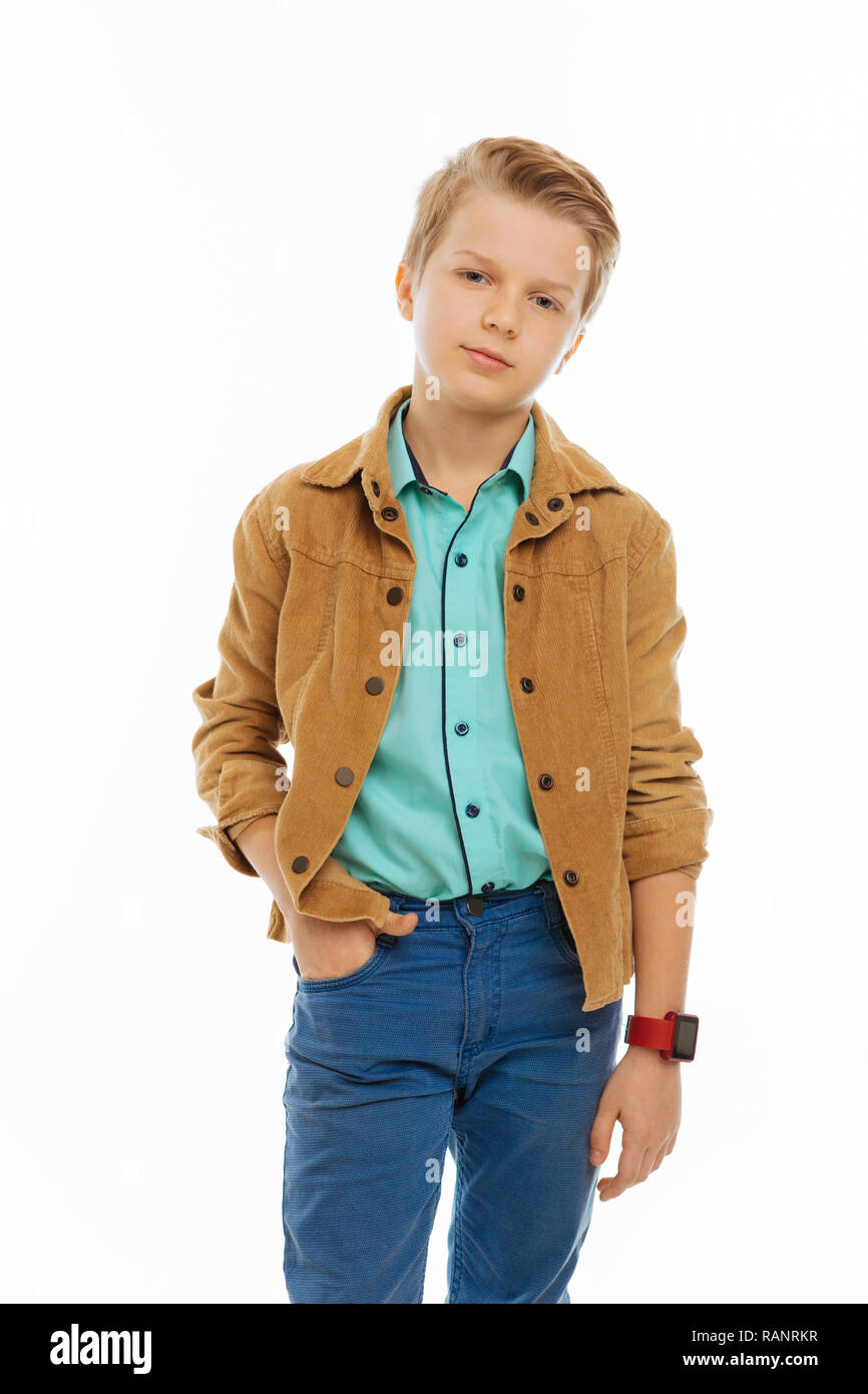 Nice serious boy putting a hand in his pocket Stock Photo - Alamy