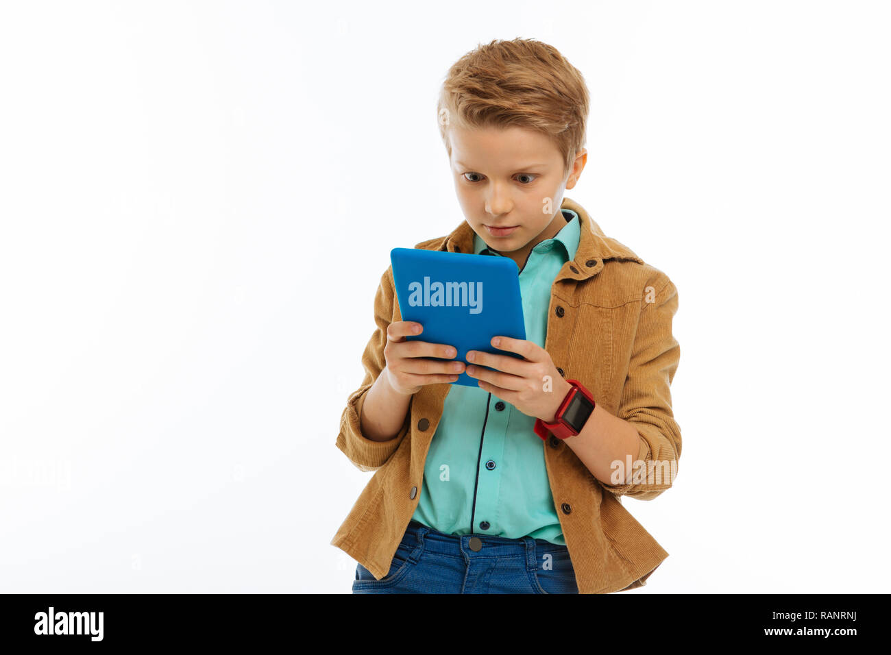 Nice impressed boy looking at the tablet screen Stock Photo - Alamy