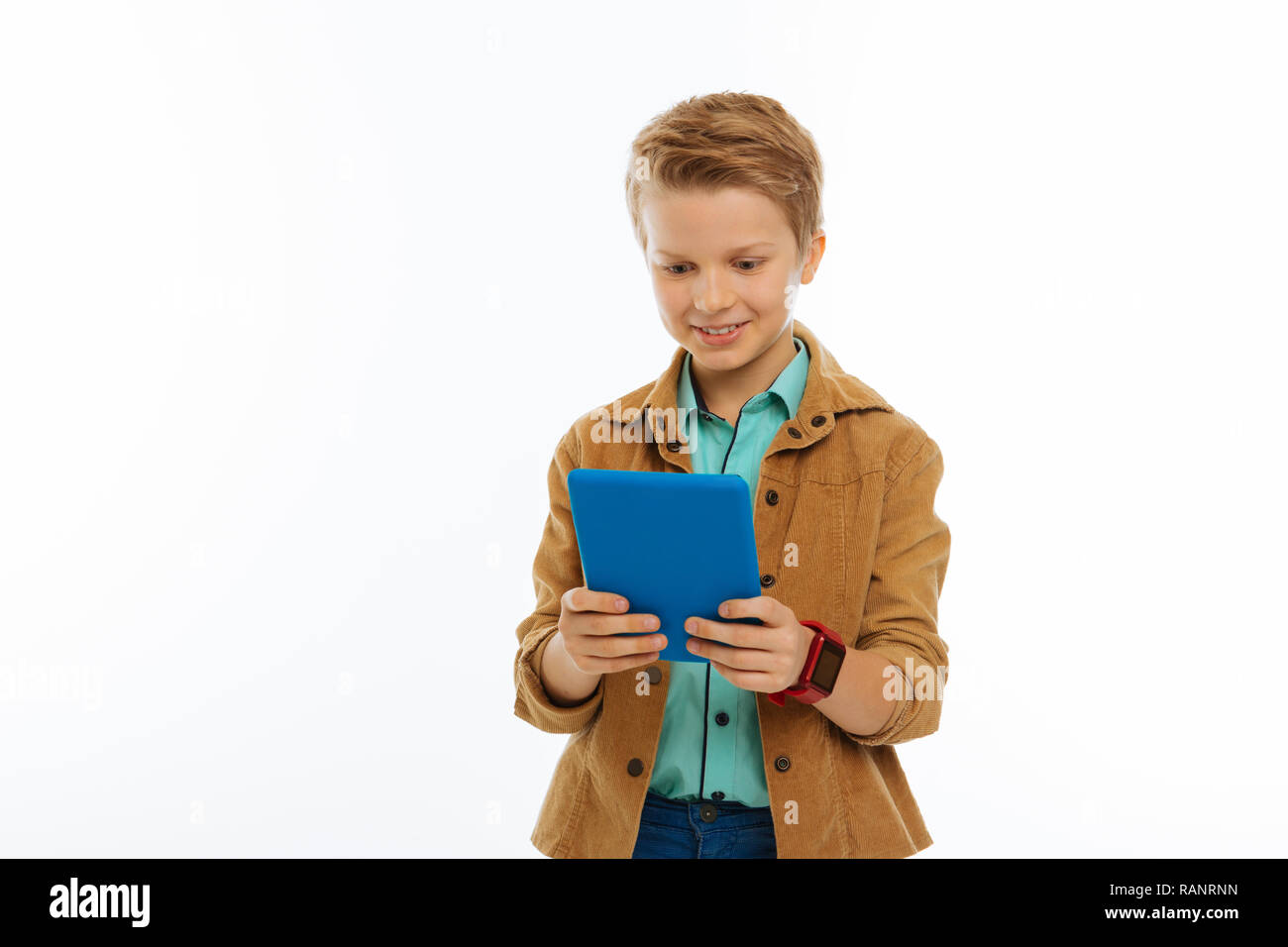 Happy positive young boy holding his tablet Stock Photo - Alamy