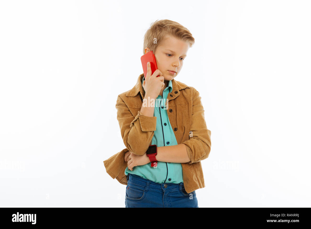 Serious cute boy answering the phone call Stock Photo - Alamy