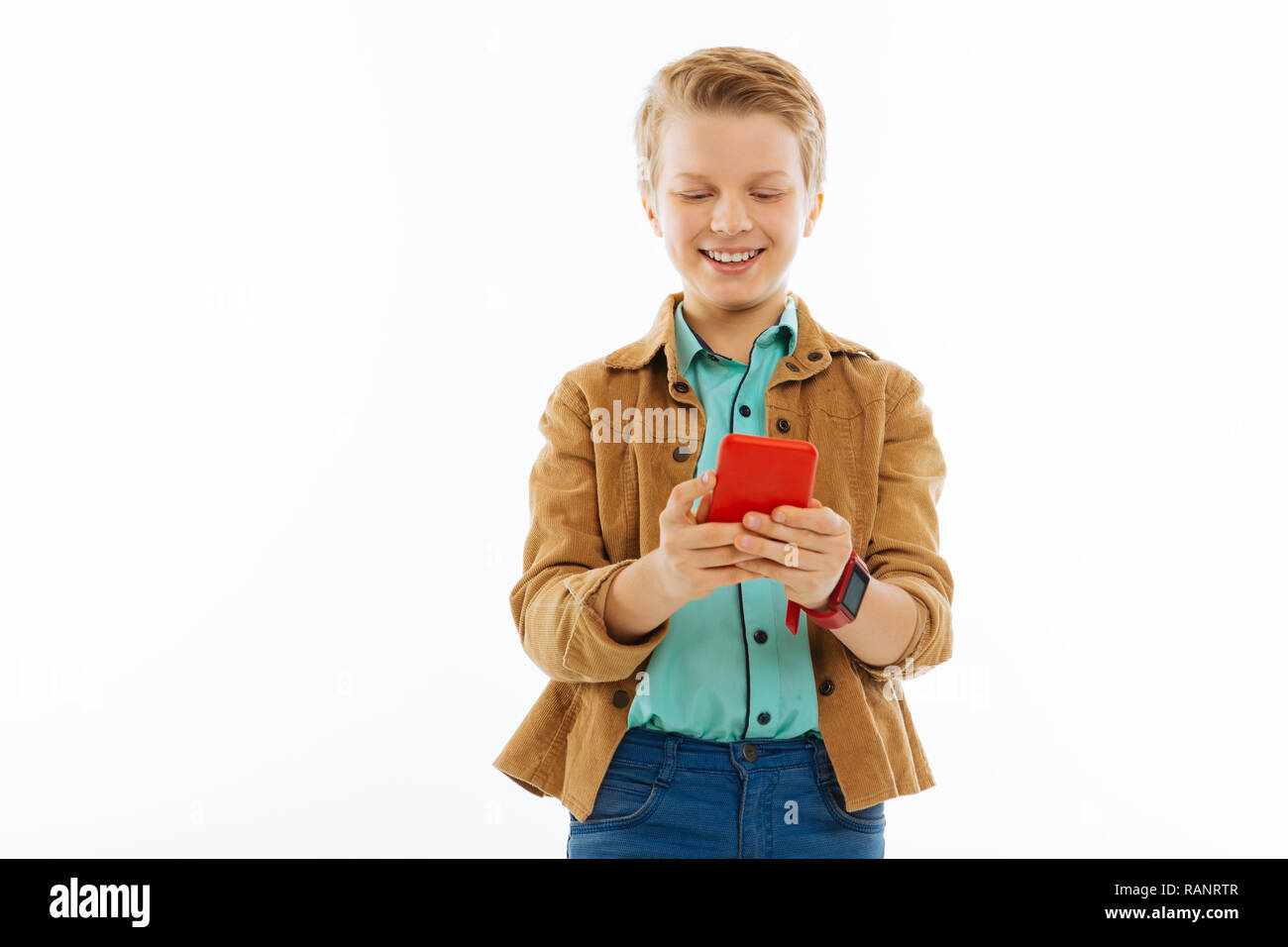 Happy nice boy typing a message on his phone Stock Photo - Alamy
