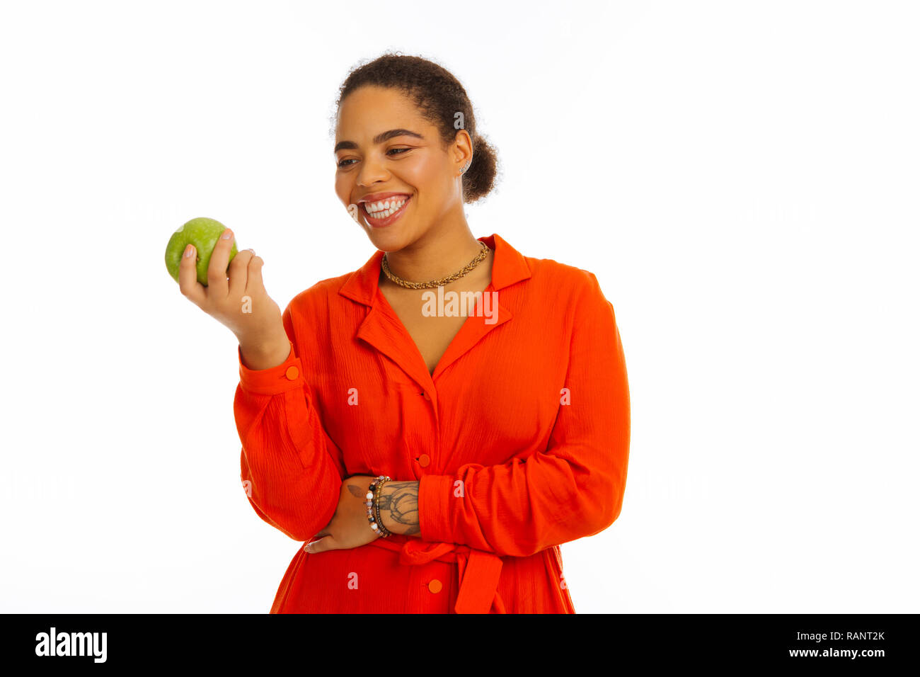 Happy positive woman looking at the apple Stock Photo - Alamy