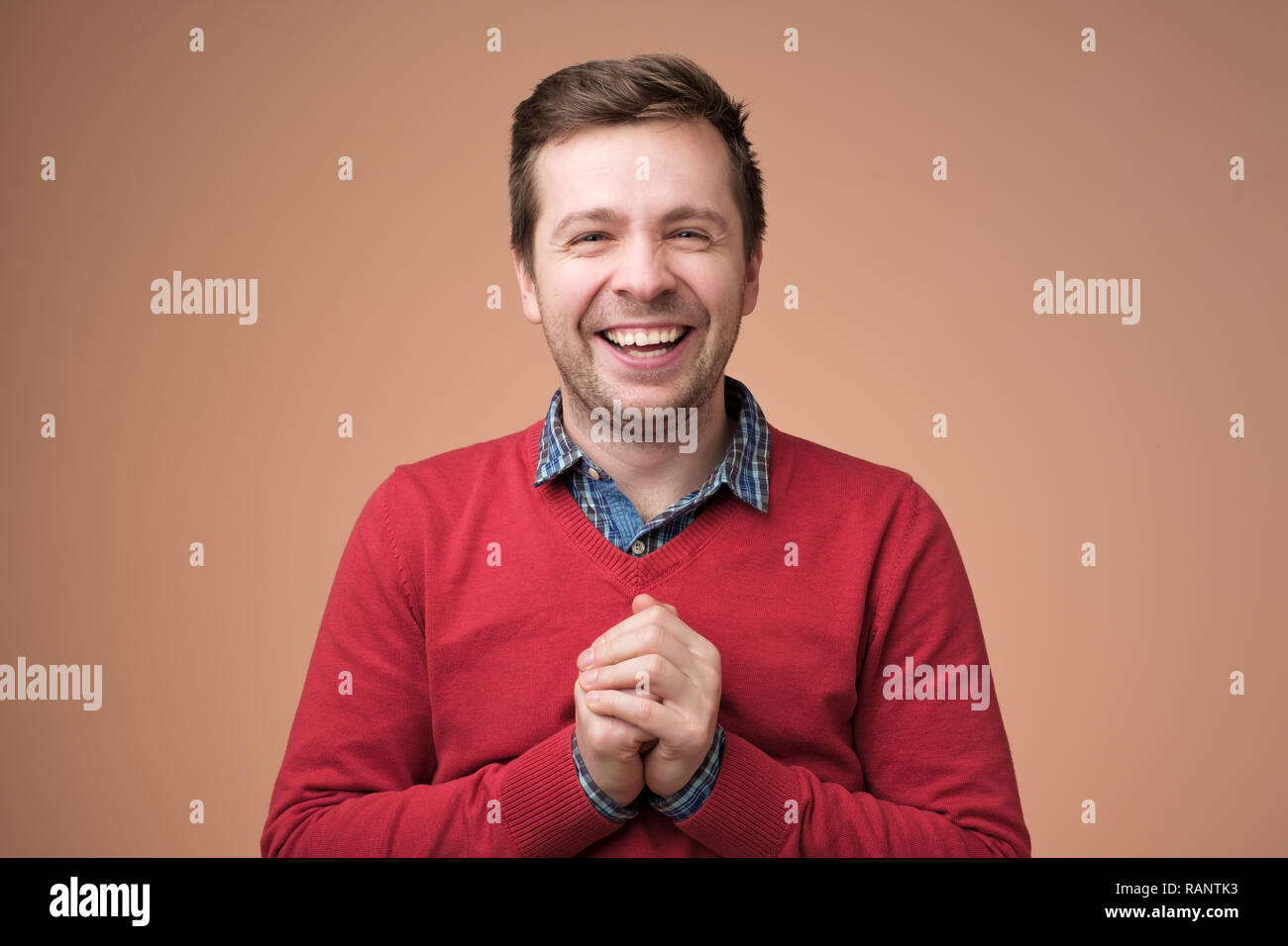 Adult good looking european man laughing, holding hands together and ...