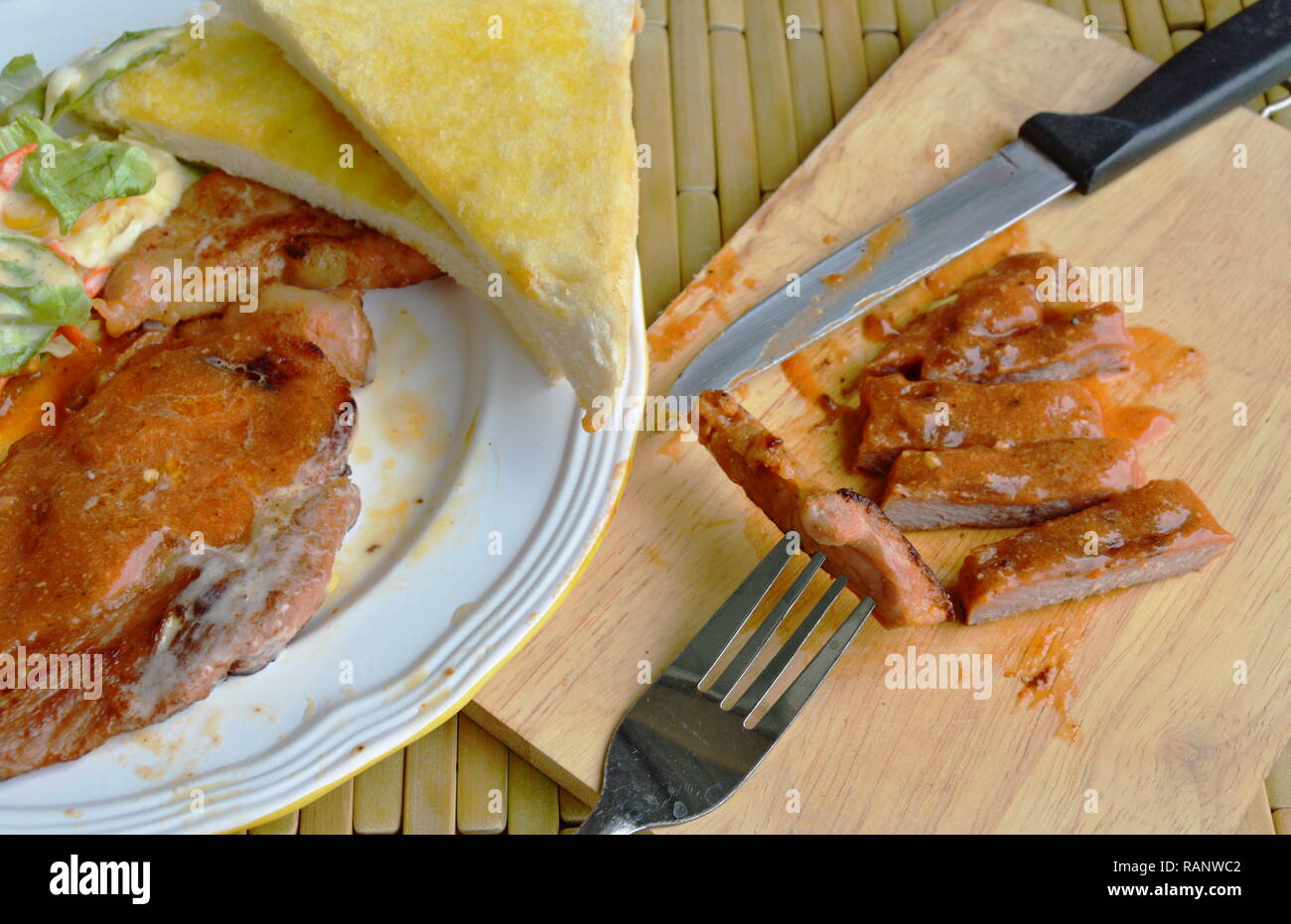 grilled pork steak cut on wooden chopping block Stock Photo - Alamy