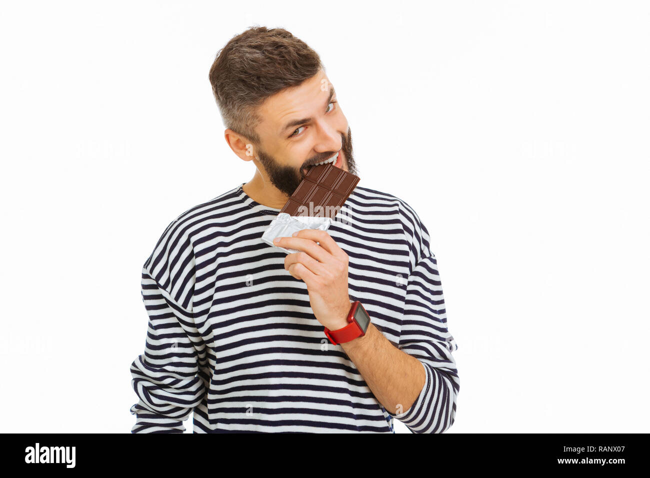 Pleasant attractive man eating a chocolate bar Stock Photo - Alamy