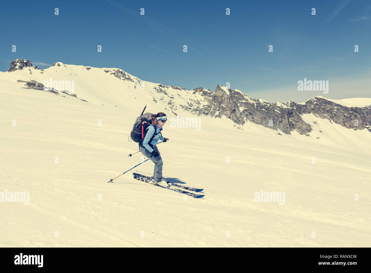 Female back-country skier tackling a steep slope. Ski touring in the ...