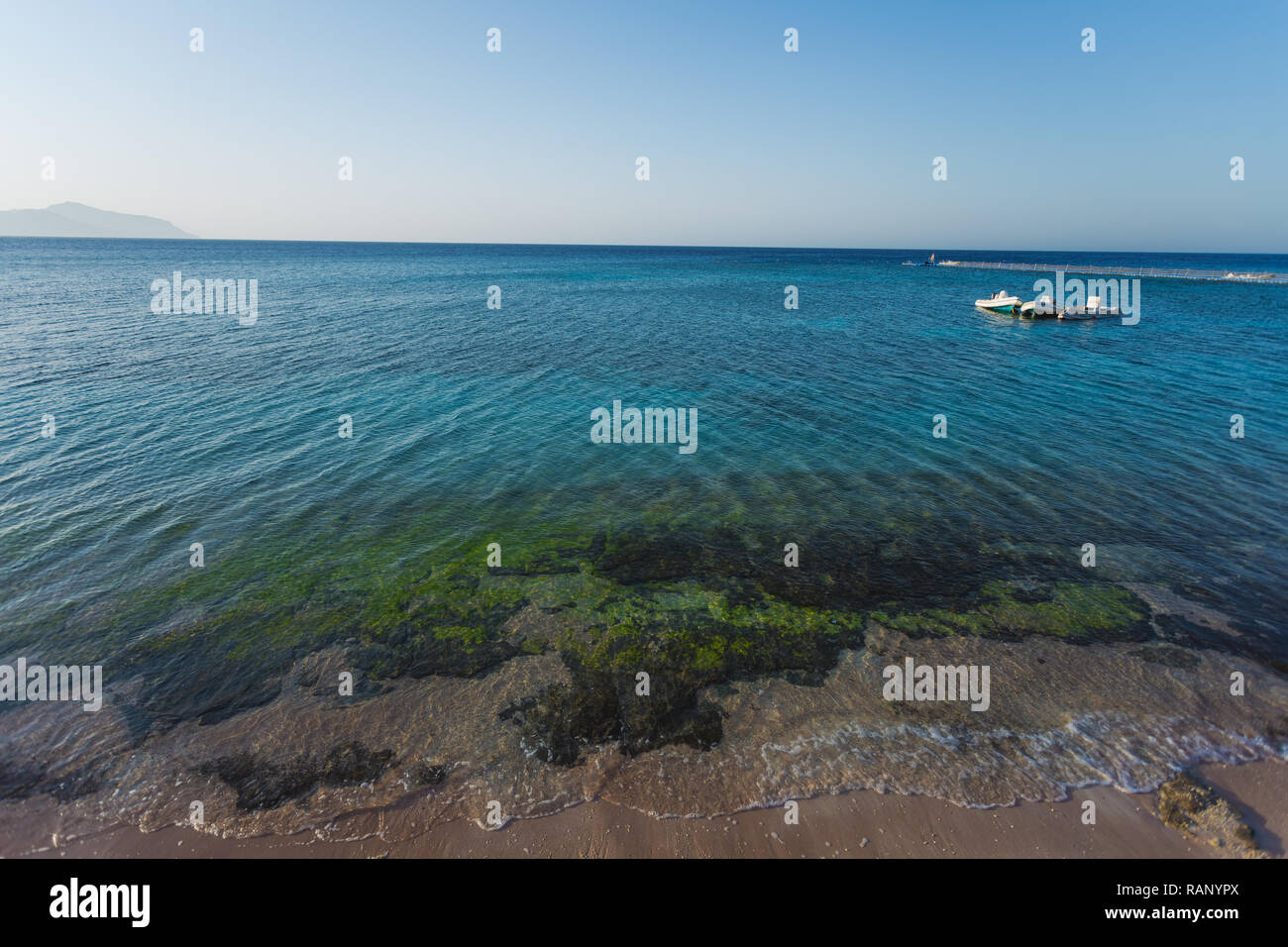 Three motorboats in distance. Blue marine water and clear sky ...