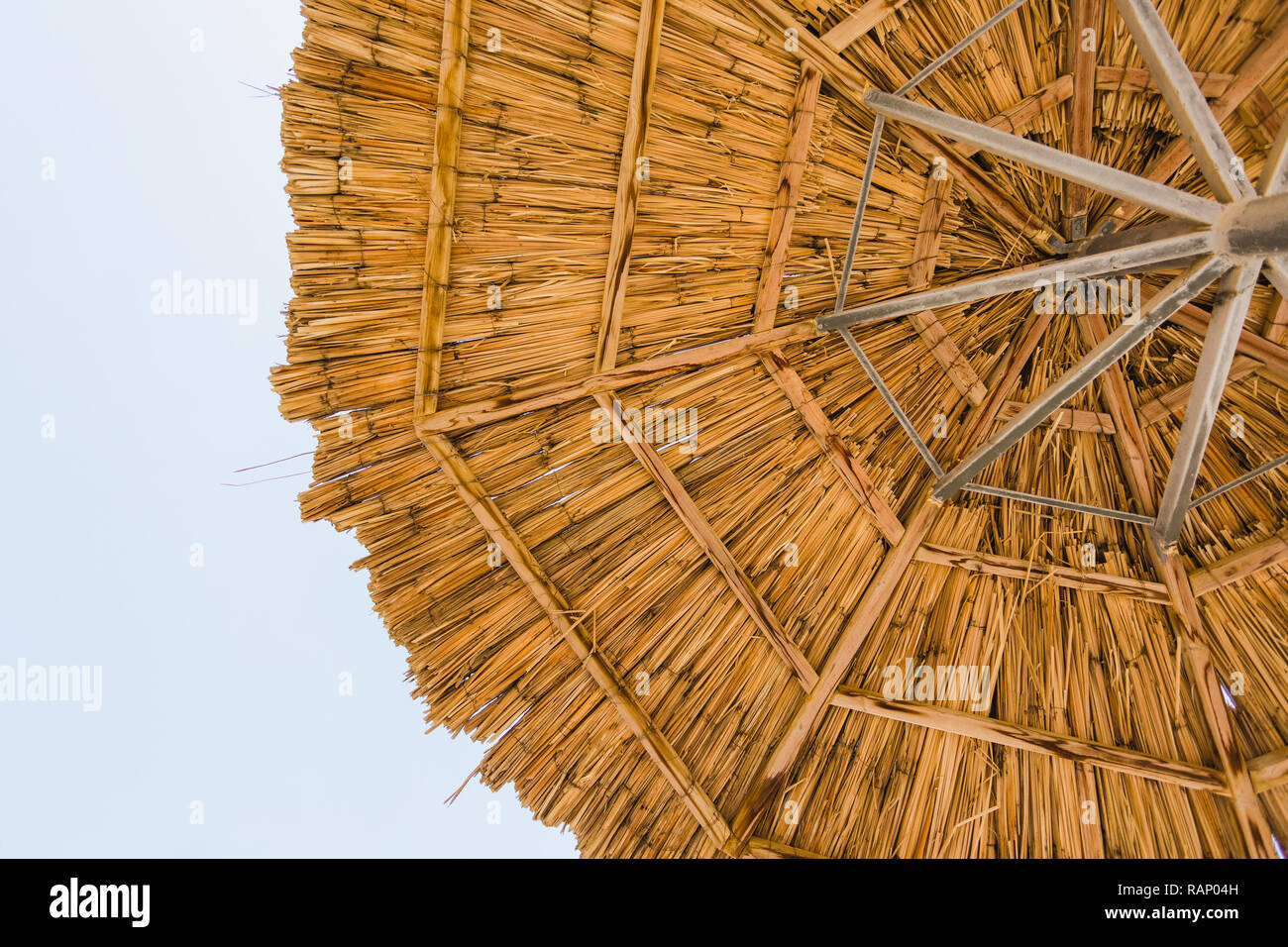 Brown beach umbrella isolated on blue sky background. Healthy and safe ...