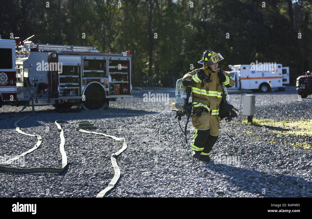 A firefighter from the 23d Civil Engineer Squadron carries oxygen tanks ...