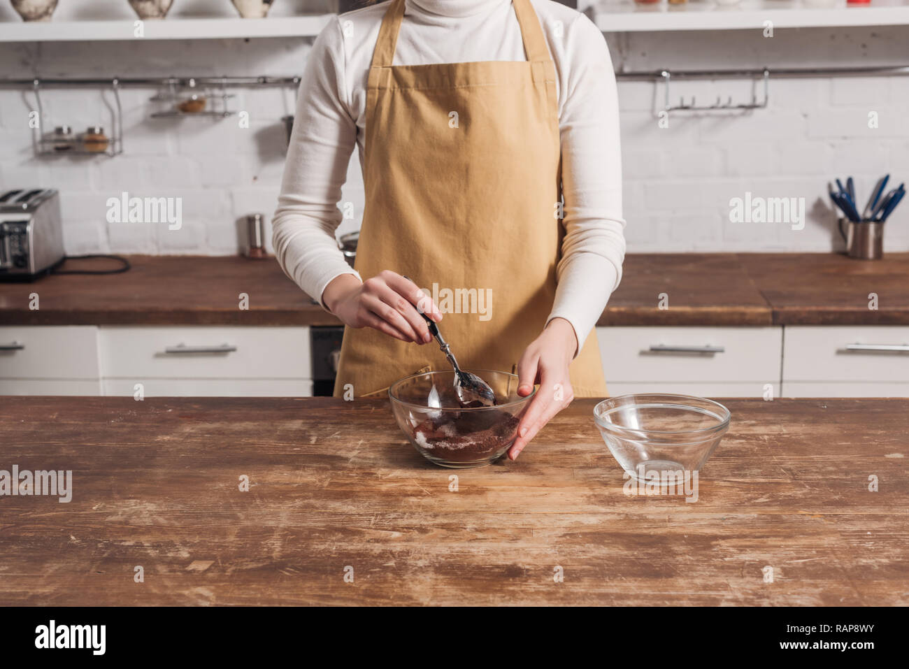 mid section of woman in apron mixing ingredients and preparing gourmet ...