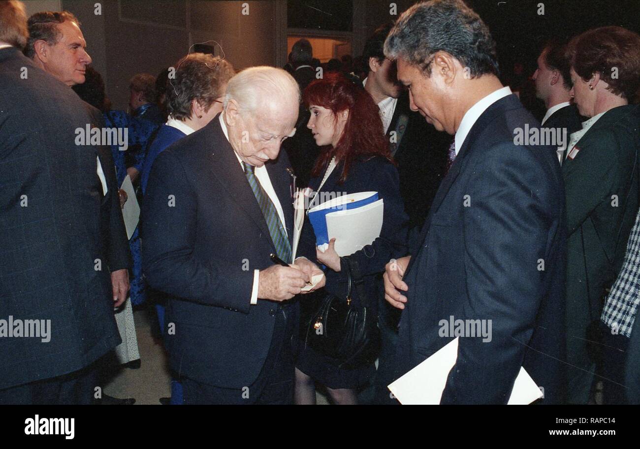 TWO MEN ARE HAVING A CONVERSATION WITH ONE OF THE MEN WRITING ON SOME ...