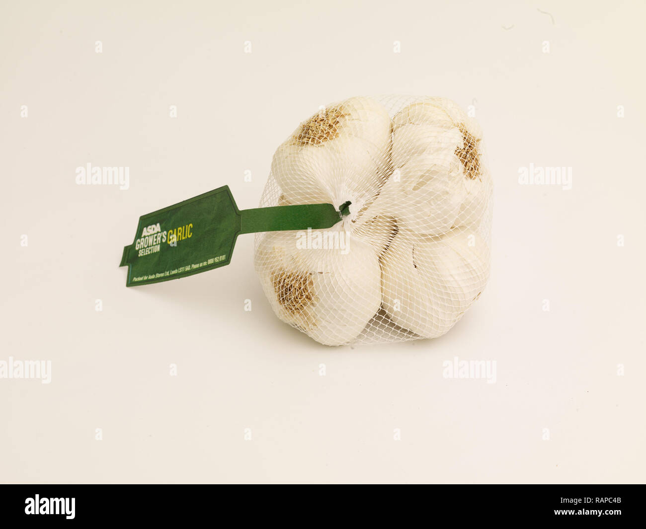 Garlic in net bag on white background food photograph Stock Photo - Alamy