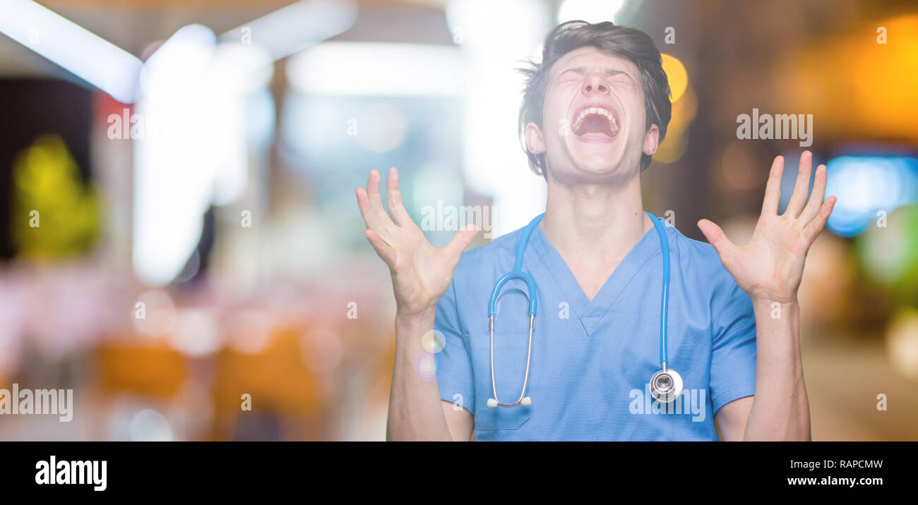 Young doctor wearing medical uniform over isolated background ...