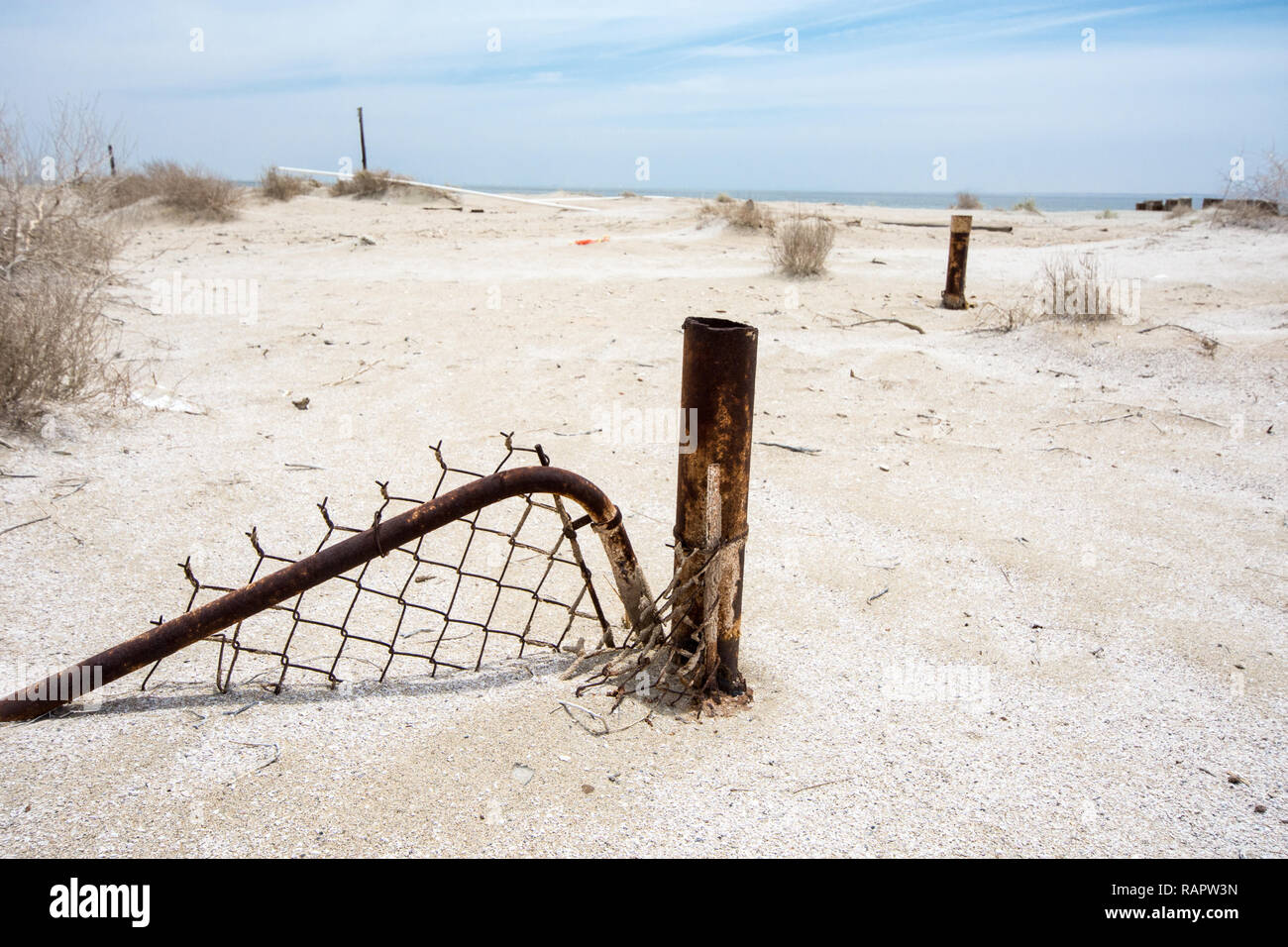 Abandoned fence gate sits buried in the sand in Bombay Beach California ...