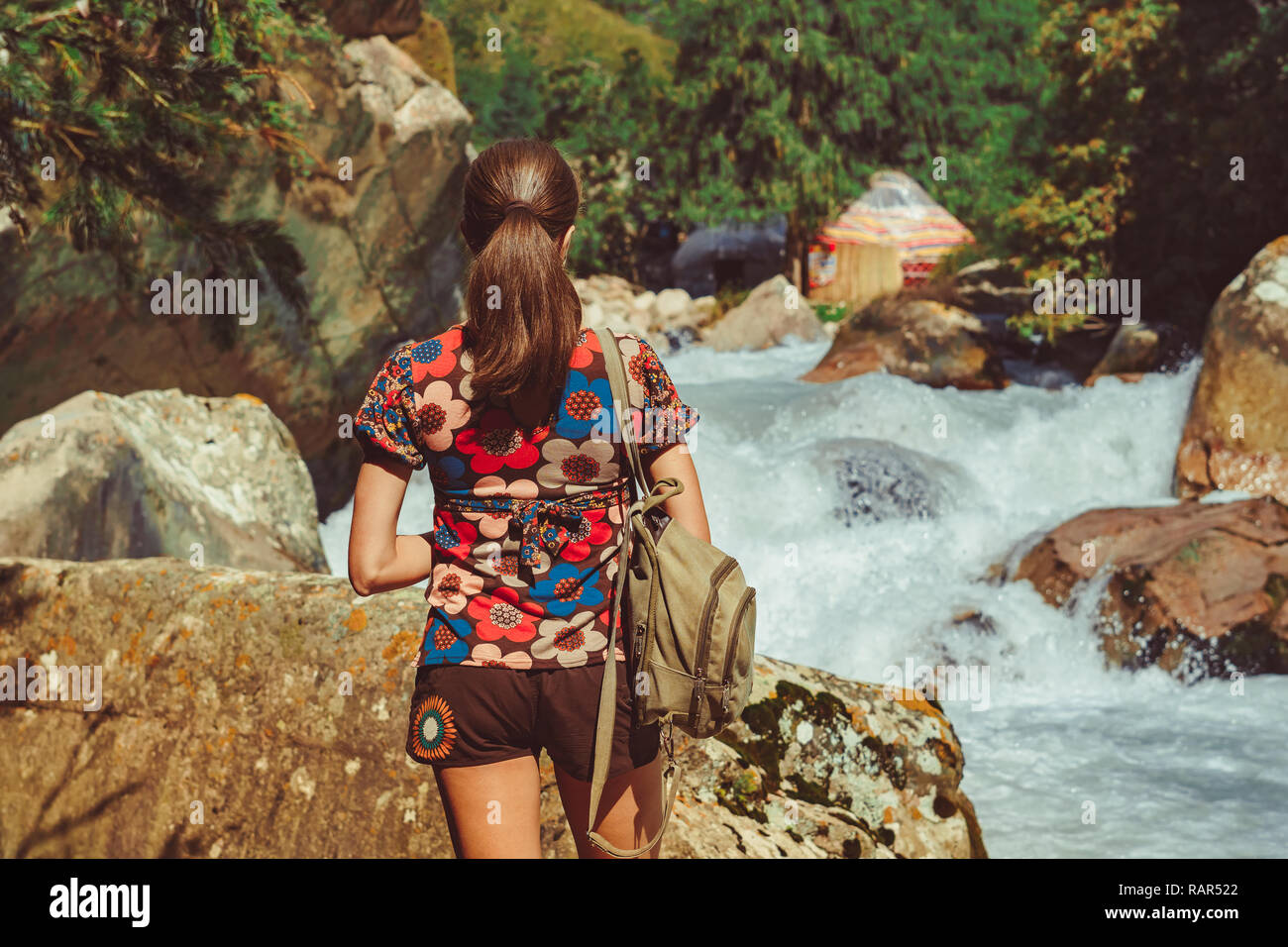 woman traveler with backpack looking at amazing mountains and river ...
