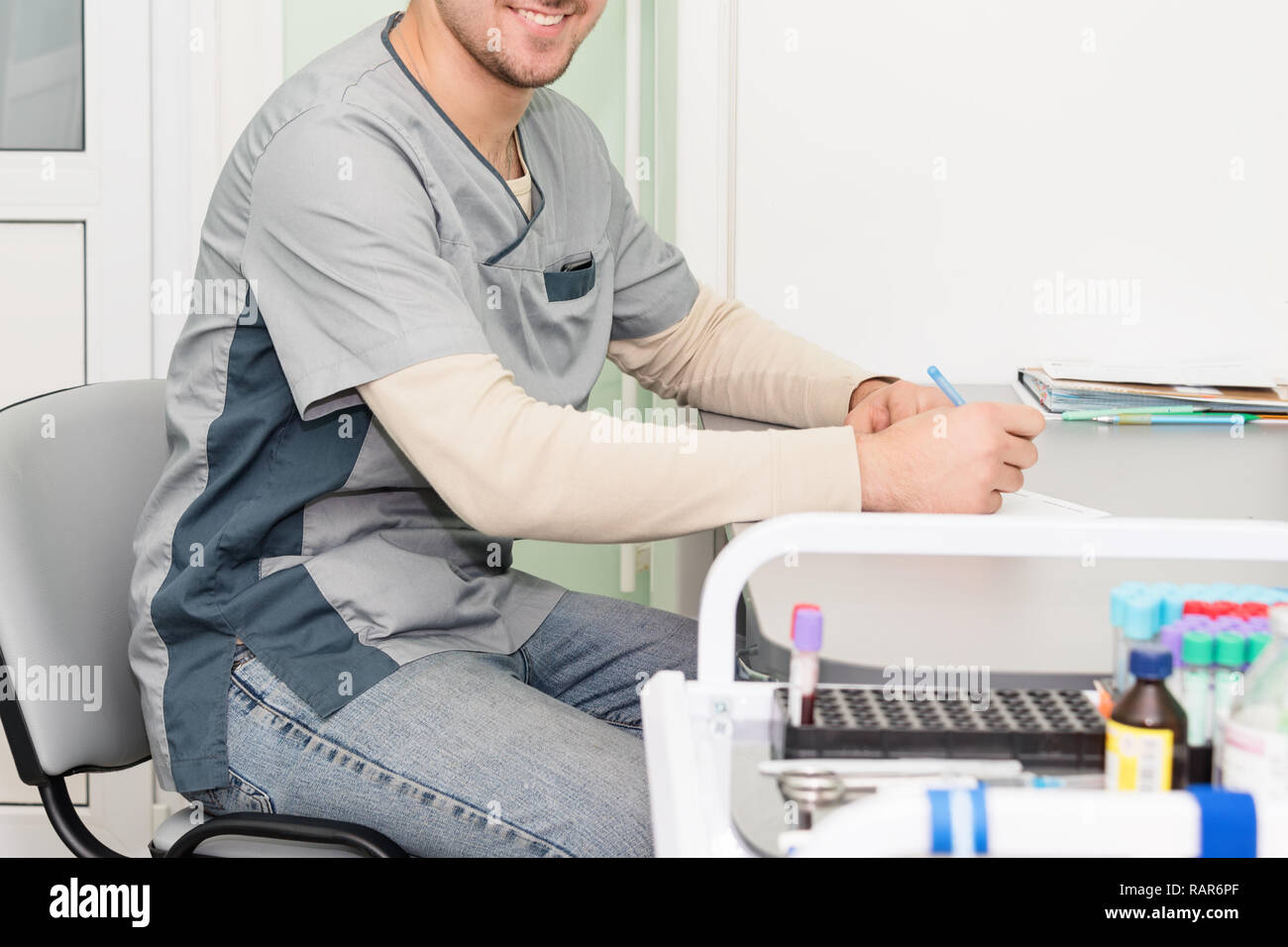 Doctor working, writing on paperwork. Modern hospital background Stock ...