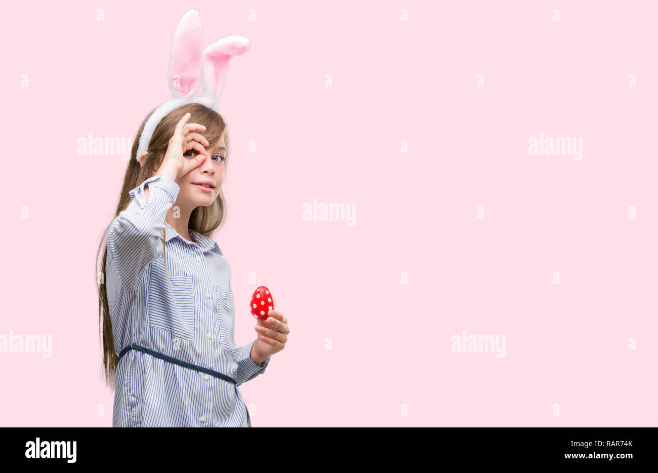 Young blonde child wearing easter bunny ears with happy face smiling ...