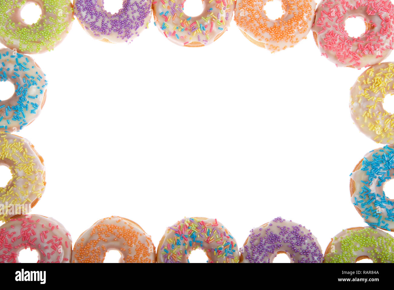 Flat lay view of many Frosted donuts with candy sprinkles arranged in a ...