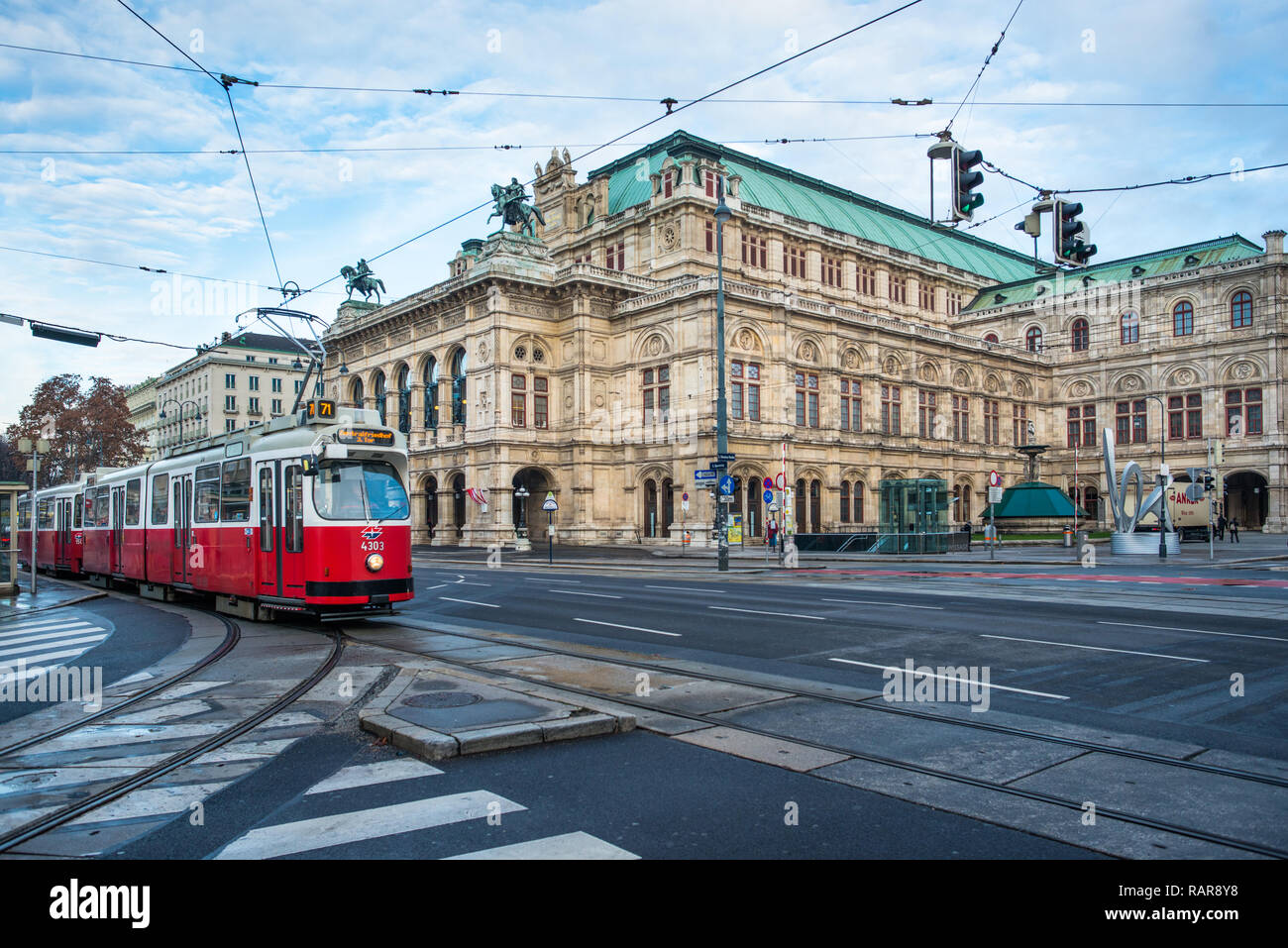 A red tram passes the State Opera House on Ringstrasse, Vienna, Austria ...