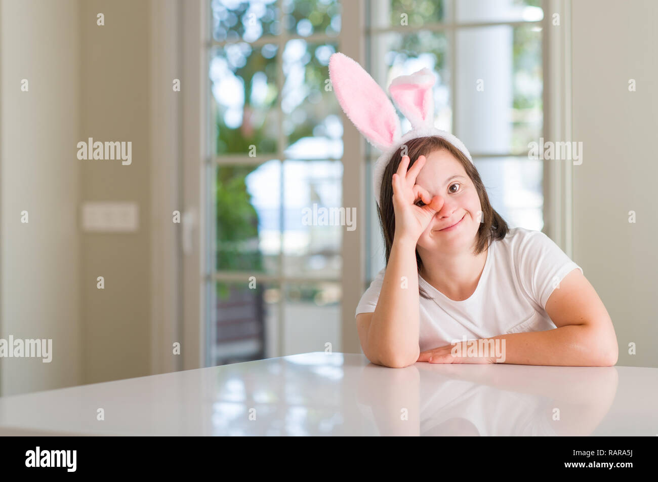 Down syndrome woman at home wearing easter rabbit ears with happy face ...