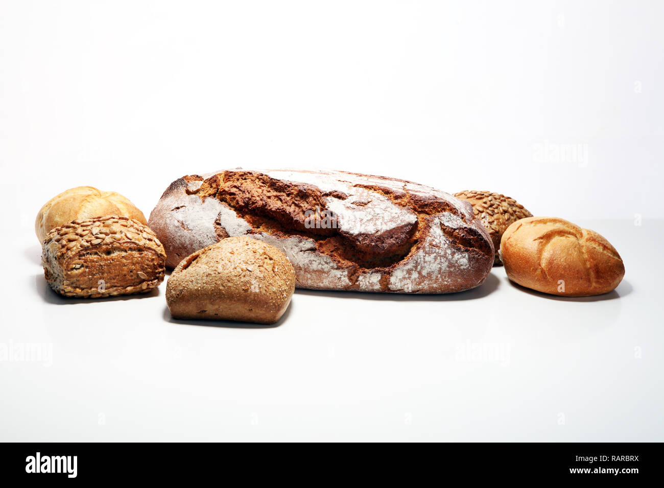 Different kinds of bread and bread rolls on board from above. Kitchen ...