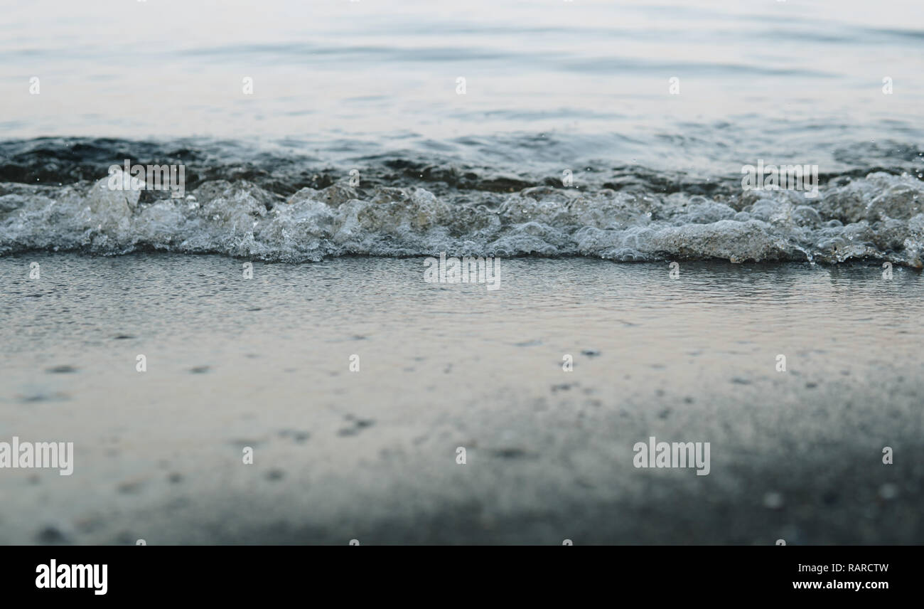 horizontal view of small waves hitting on a sandy shore Stock Photo - Alamy