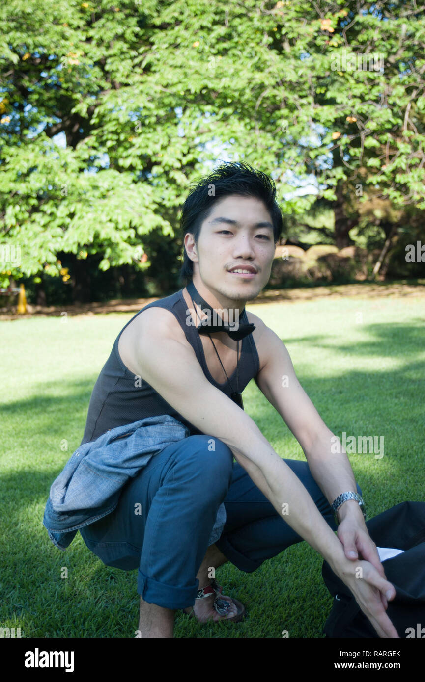 Asian male model poses for pictures on the street Stock Photo - Alamy